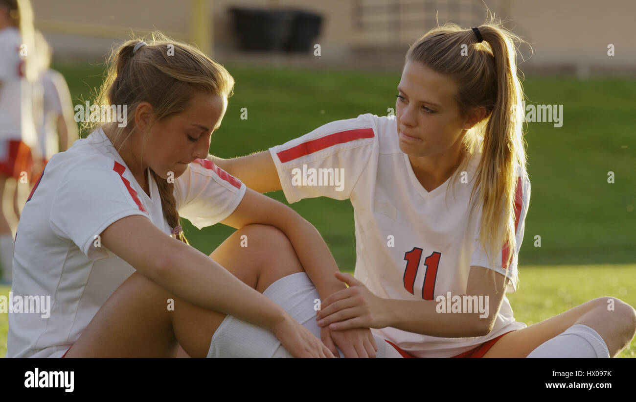 Serious soccer athlete comforting teammate after losing game outdoors ...