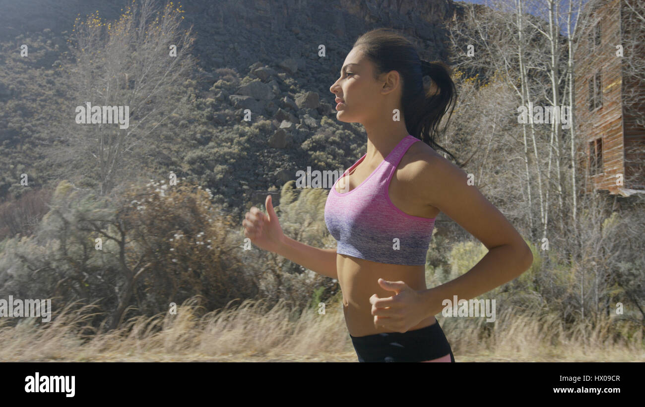 Profile of serene runner jogging in remote forest landscape Stock Photo ...