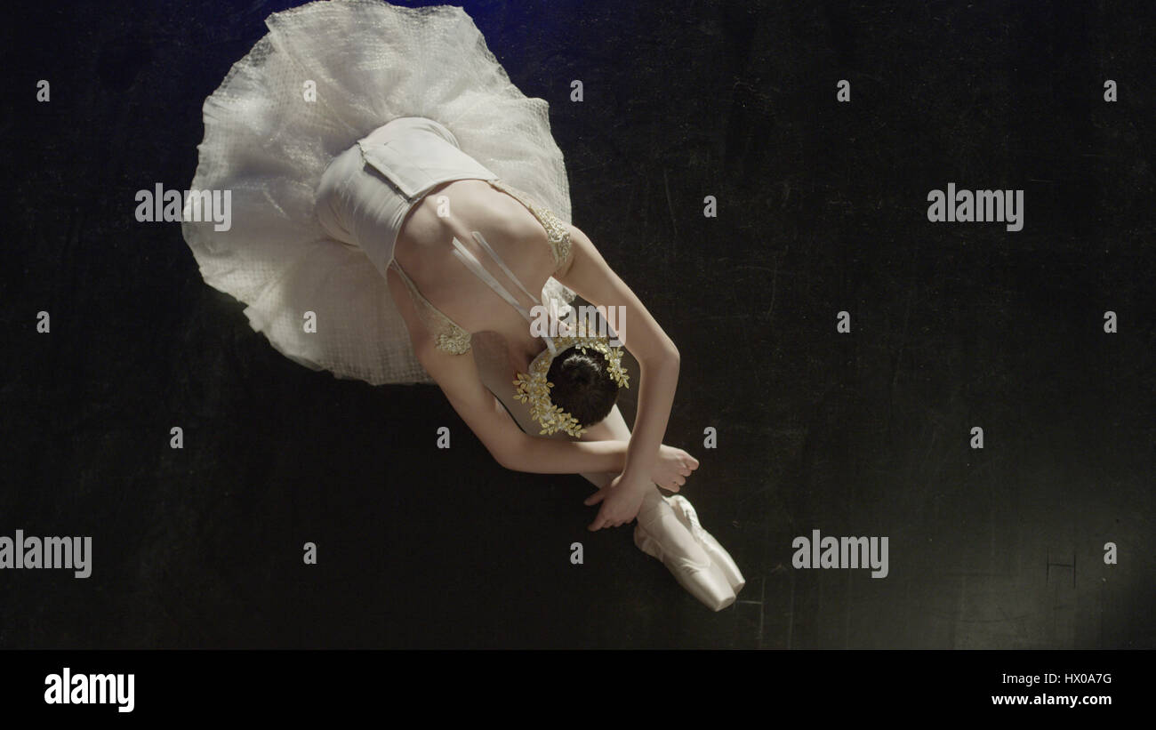 Overhead view of ballet dancer stretching in costume before show Stock ...