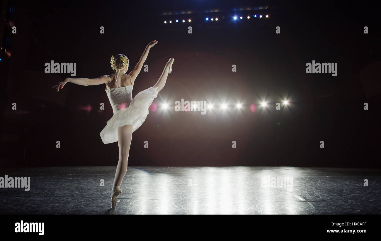 Rear view of serious ballet dancer in costume performing onstage in ...