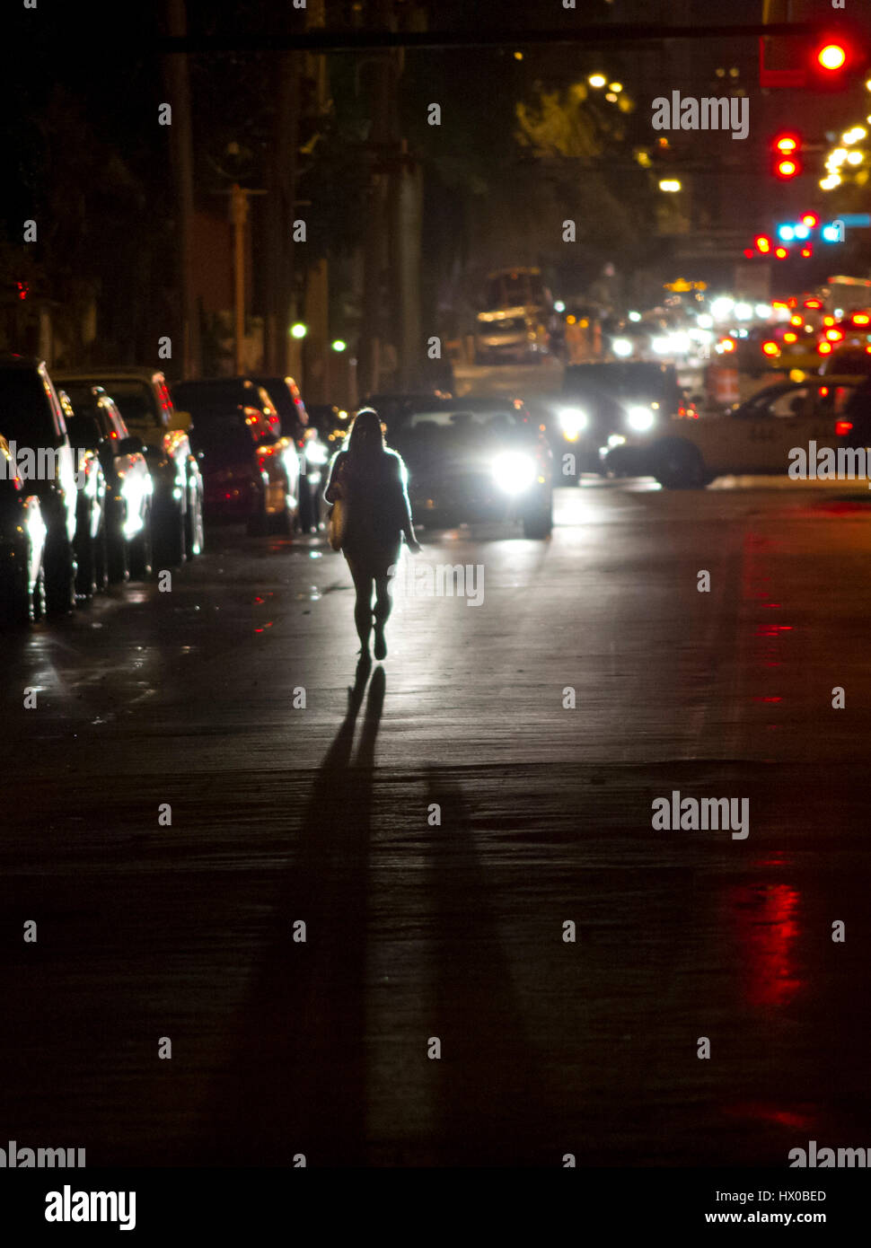 Woman walking on a street of a city at night Stock Photo - Alamy