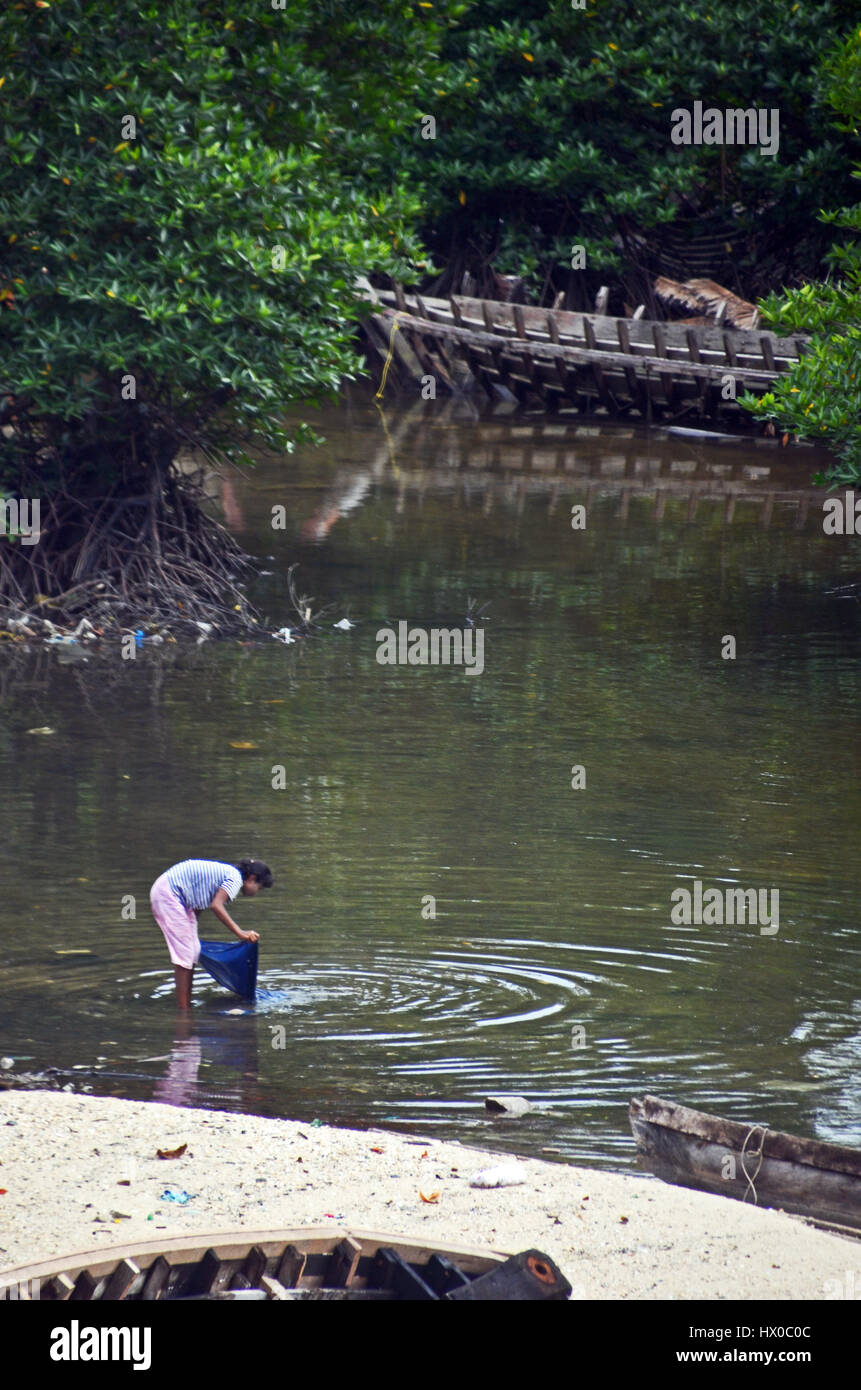 A woman washes clothes in the river in the village of Makyone Galet ...