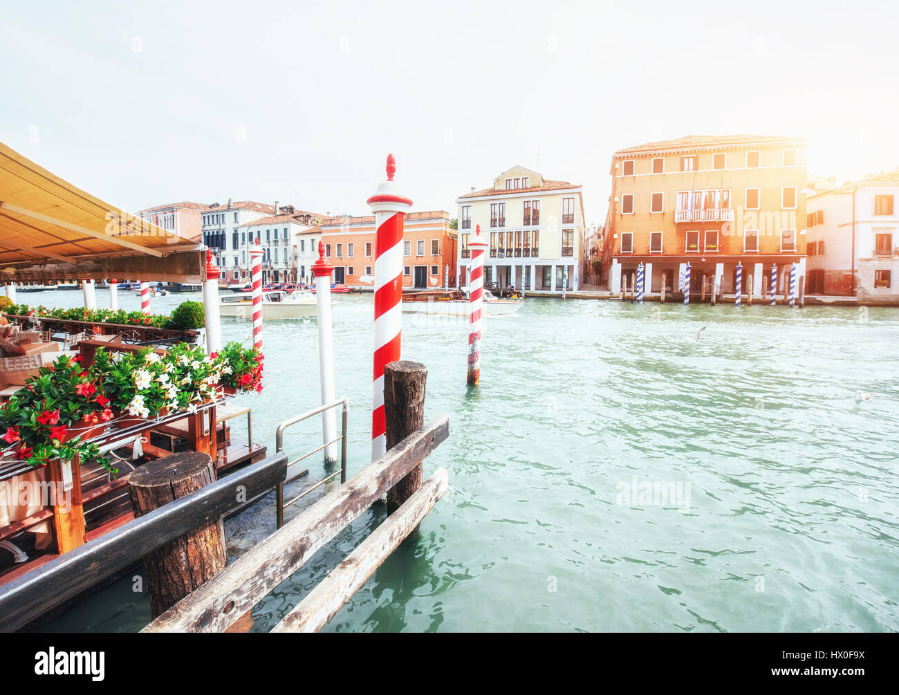 Green water channel with gondolas and colorful facades of old medieval ...