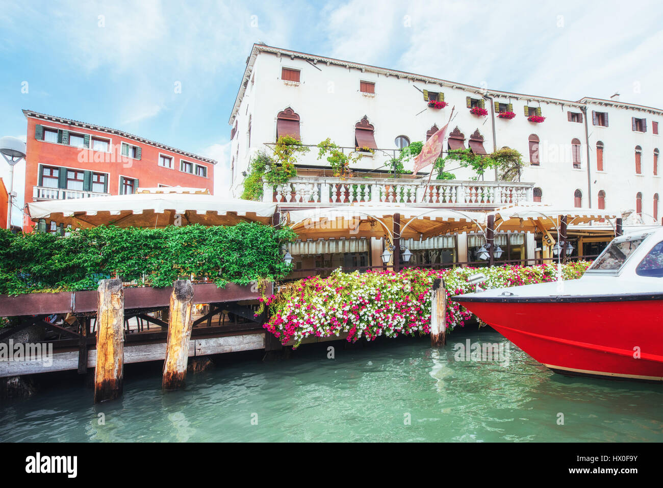 Green water channel with gondolas and colorful facades of old medieval ...
