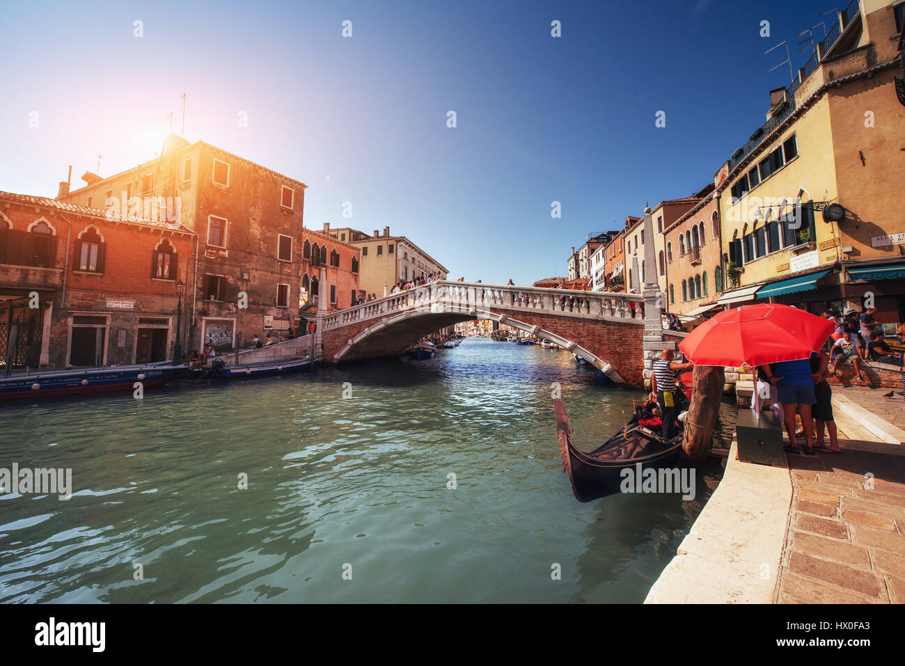 Green water channel with gondolas and colorful facades of old medieval ...
