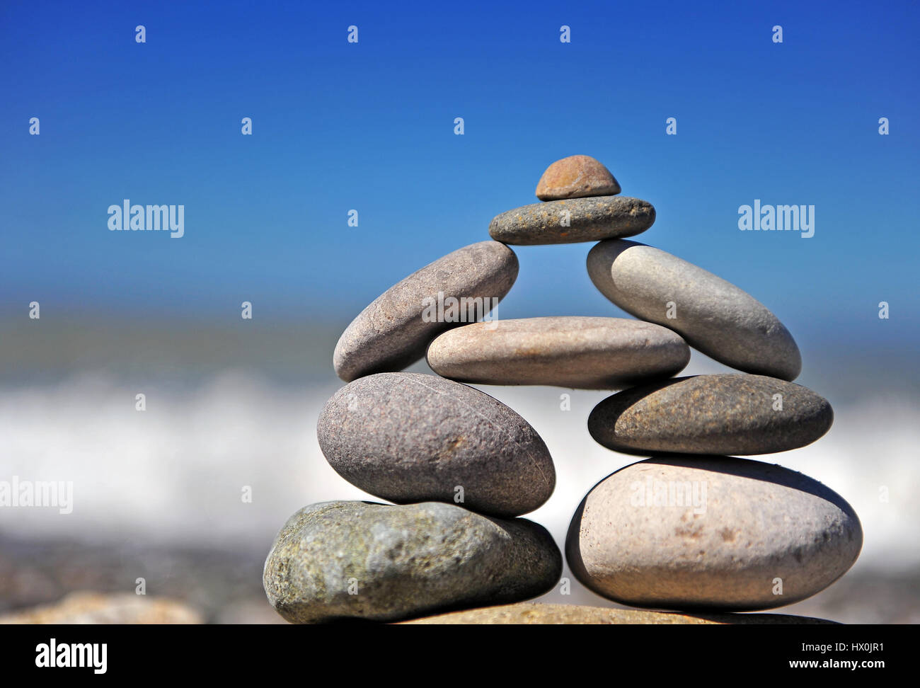 Stones pyramid standing at the sea with blue sky on background Stock ...