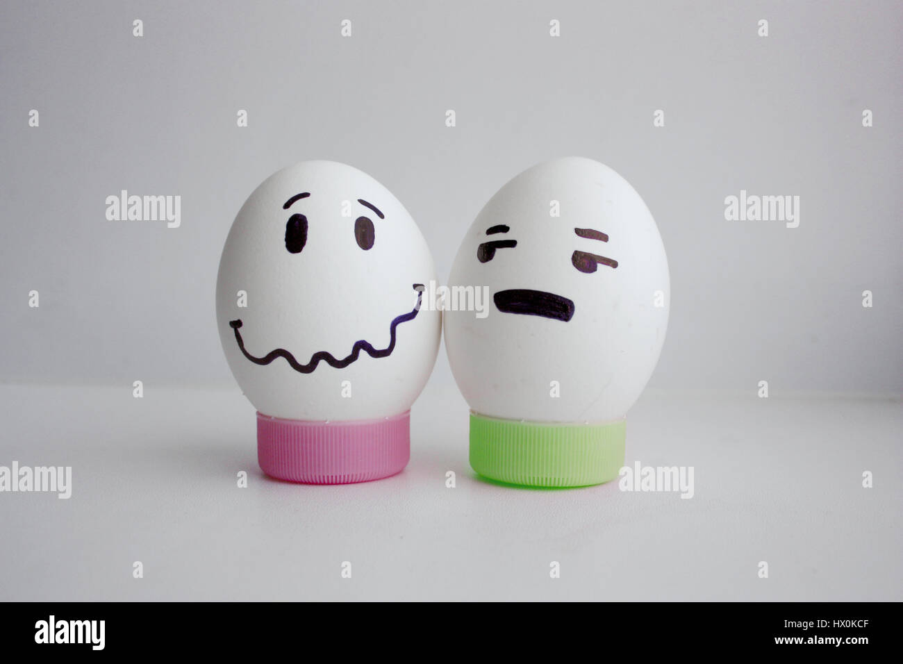 Eggs cheerful with two face on white background on stand concept of ...