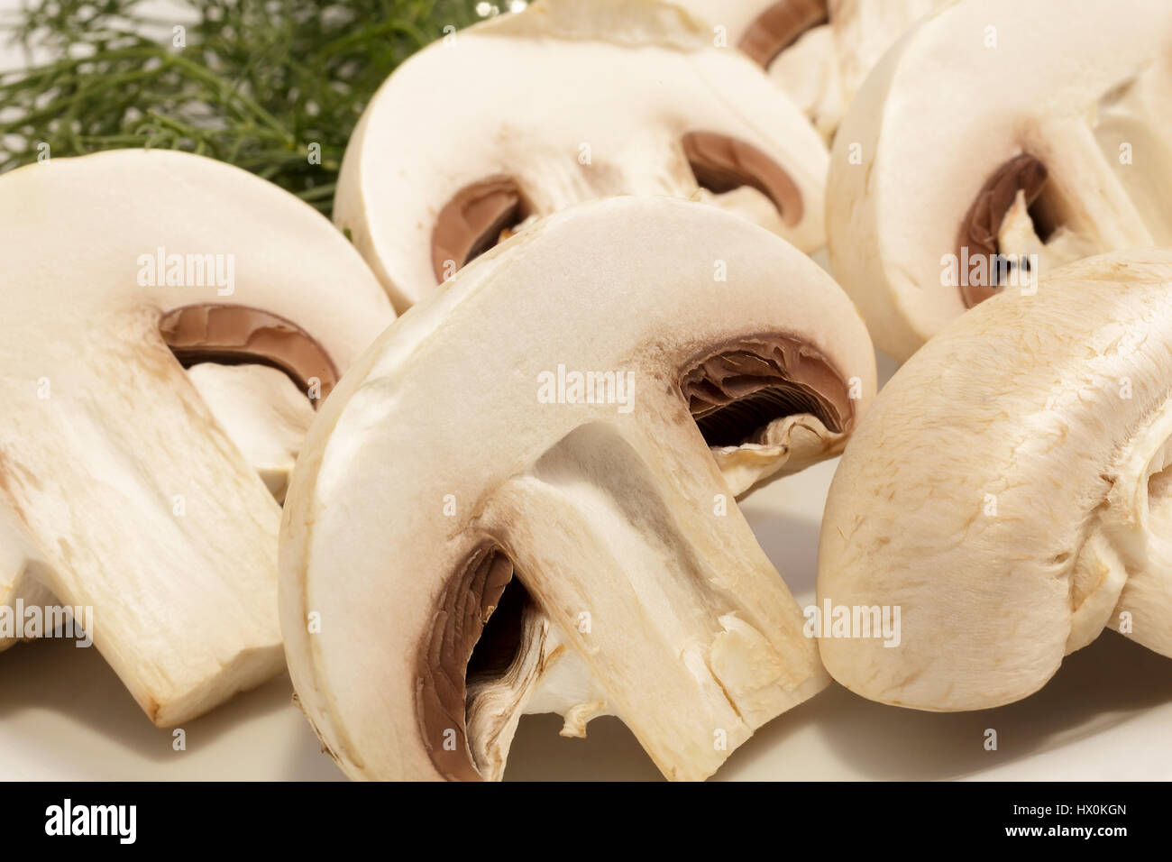 Cut champignons on a plate with greens. Close-up Stock Photo - Alamy