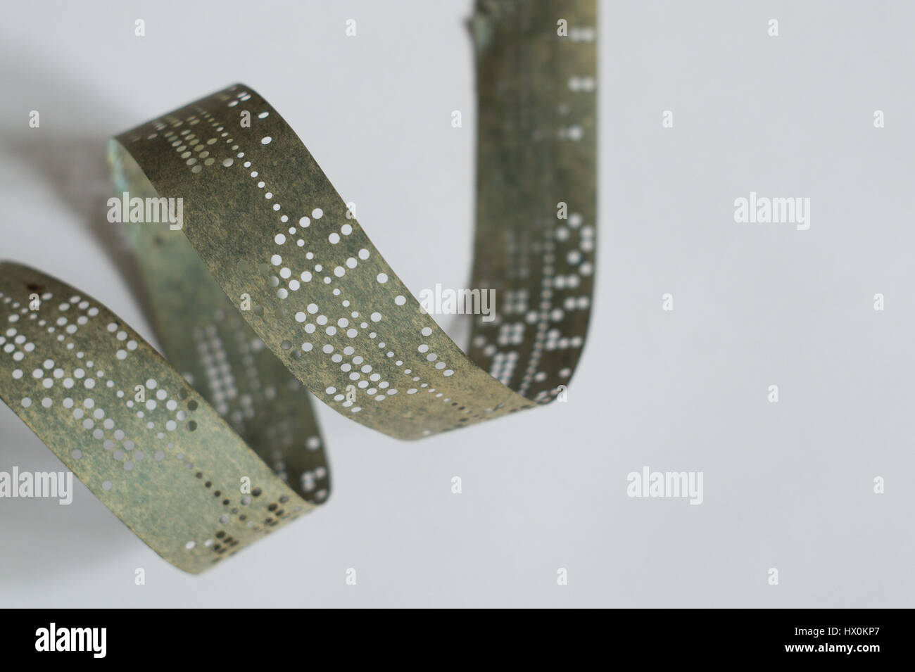 Strips of old punched tape on white surface Stock Photo - Alamy