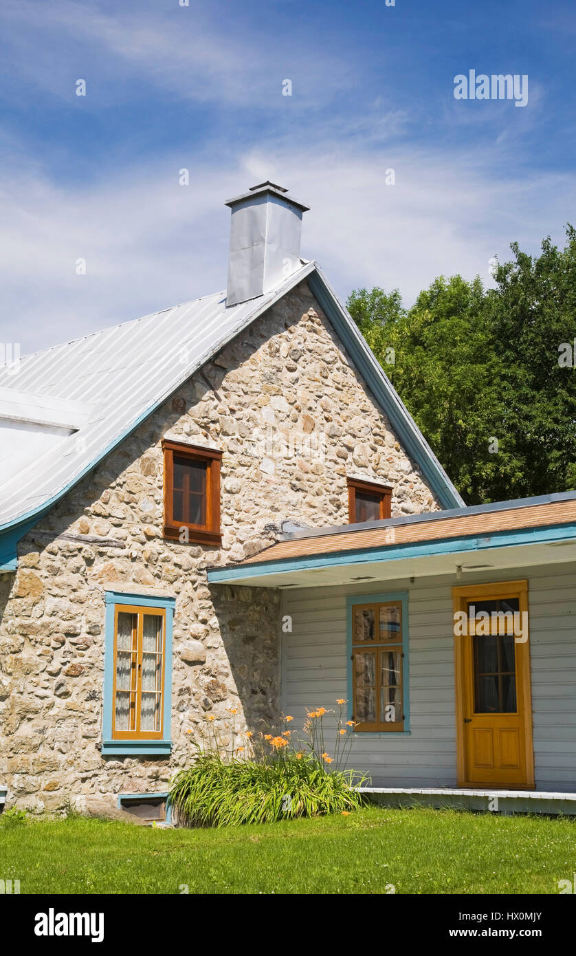 1810 old fieldstone house with blue and orange trim in summer Stock ...