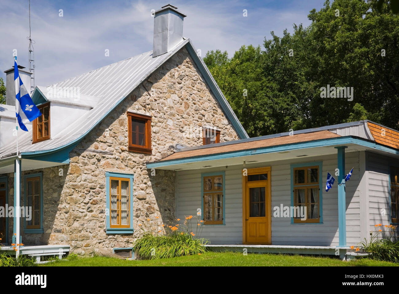1810 old fieldstone house with blue and orange trim in summer Stock ...