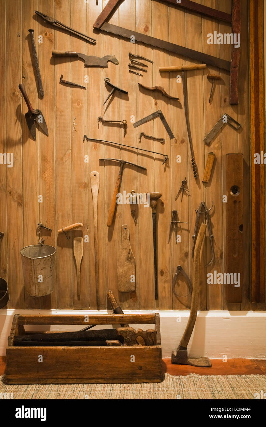 Wood paneled wall decorated with antique hand tools in hallway on 1831 ...