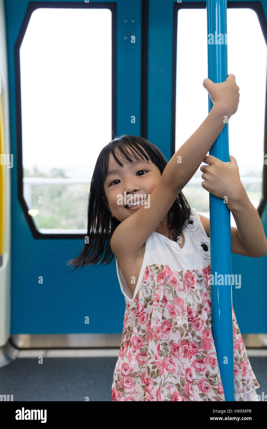 Asian Chinese little girl pole dancing inside a MRT transit in Kuala ...