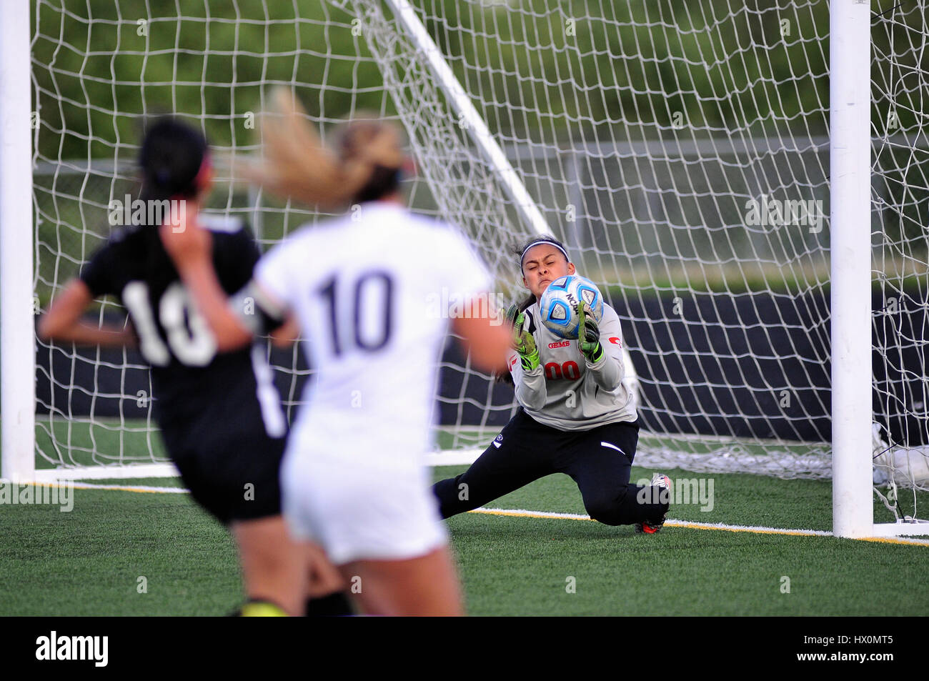 Keeper focused on attempting to make a save during a high school match ...