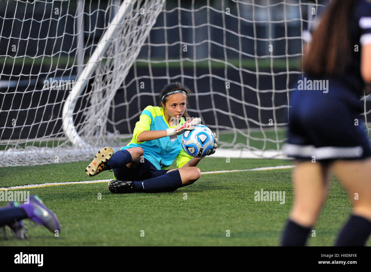 Keeper making a sliding save Stock Photo - Alamy