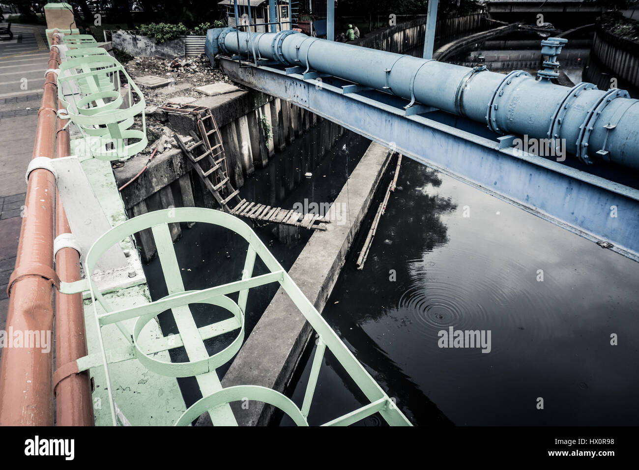 dirty river with blue water pipe crossing on top the river photo taken ...