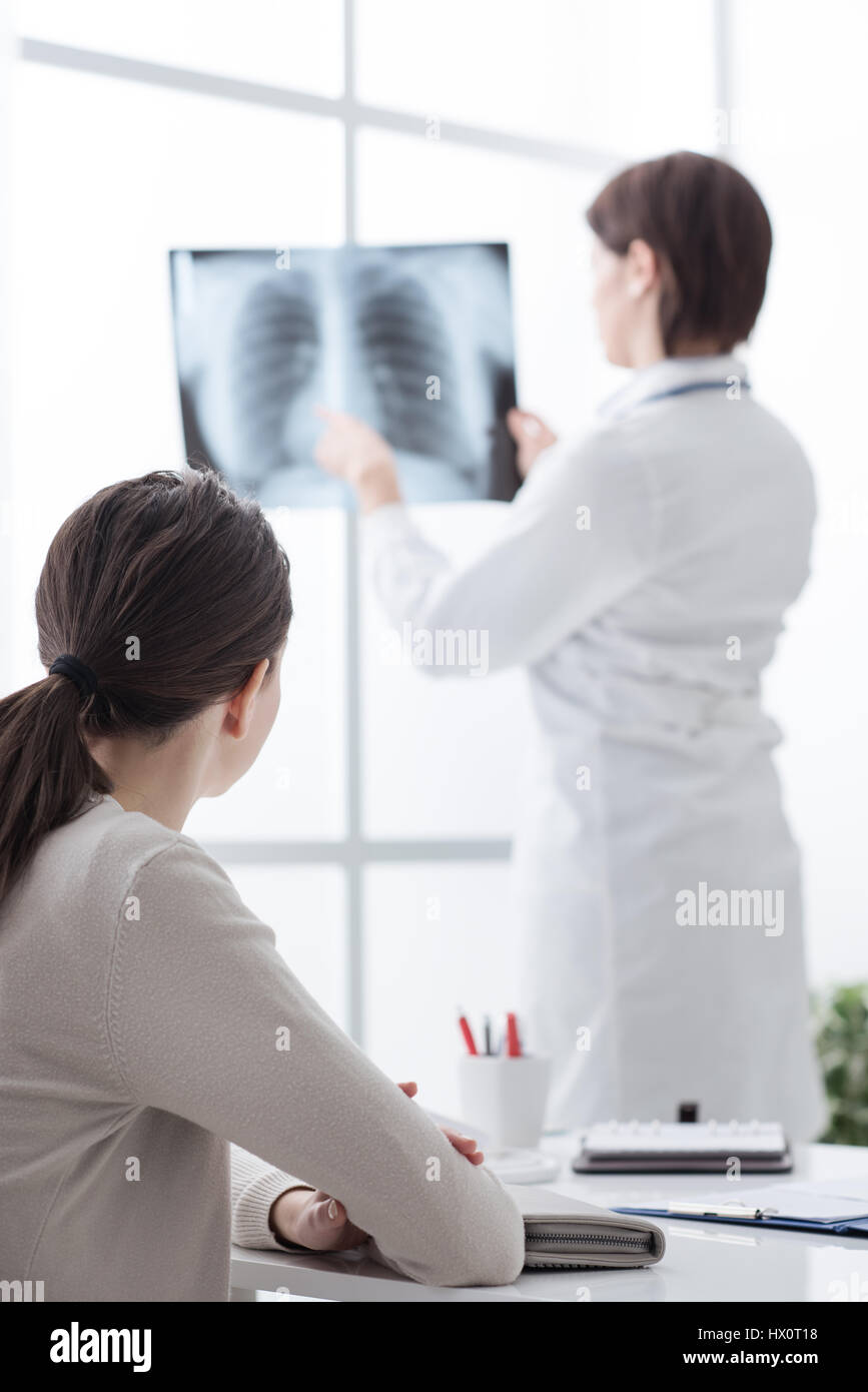 Professional doctor examining a patient's x-ray and pointing, medical ...