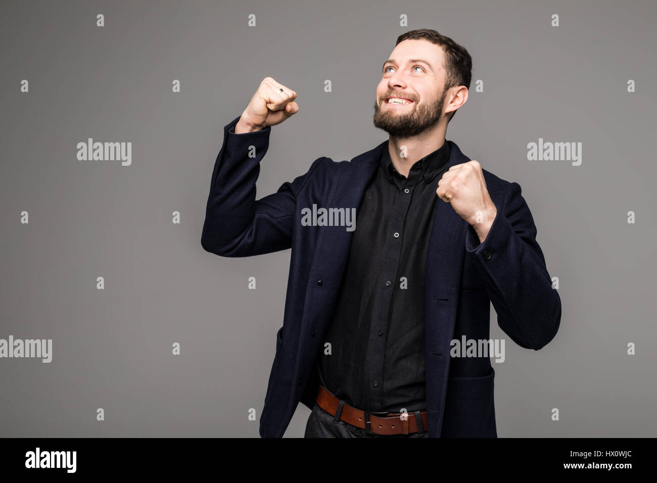 Handsome young businessman gesturing and smiling while standing against ...