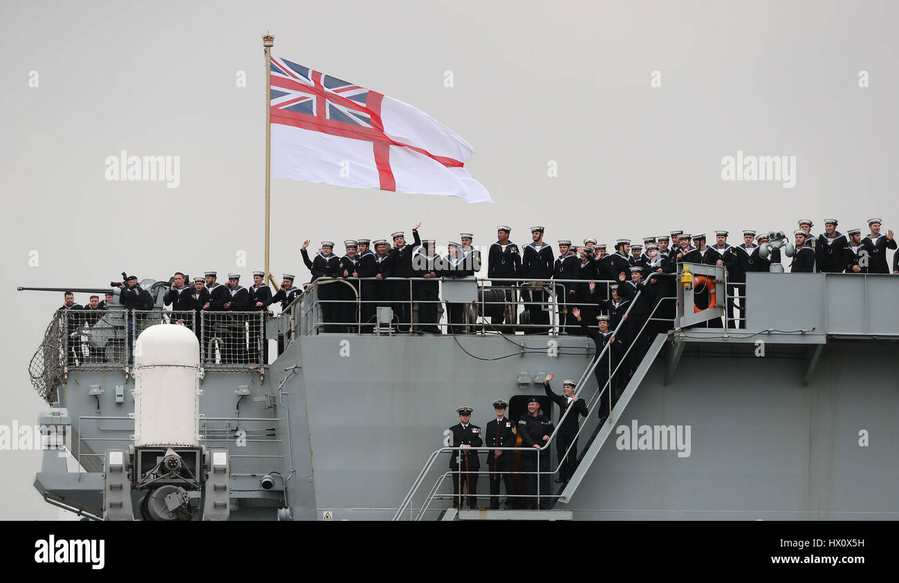 Members of the crew wave as HMS Ocean, the Royal Navy's fleet flagship ...
