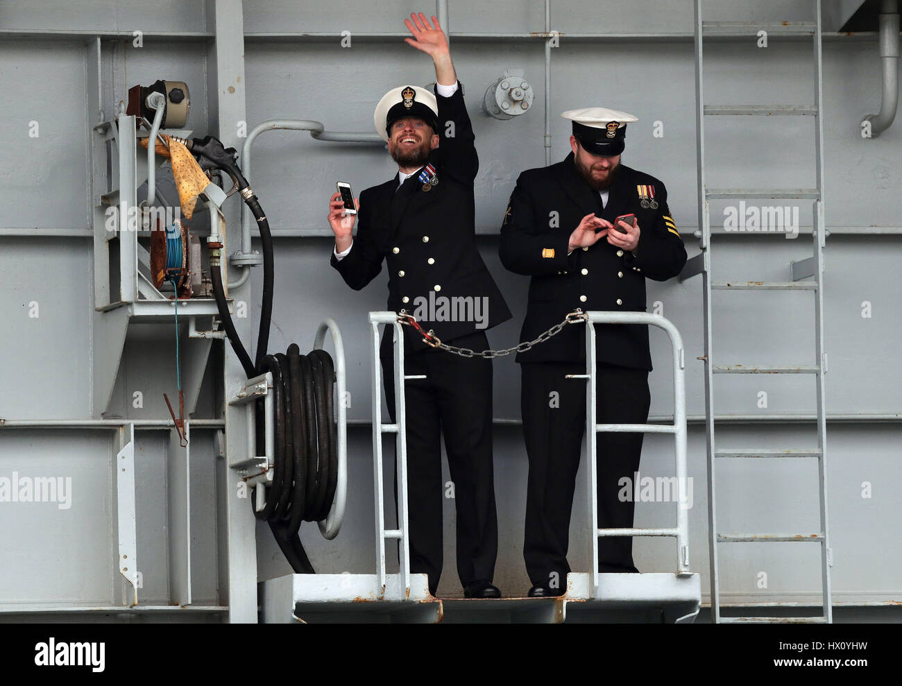 Members of the crew wave to family and friends as HMS Ocean, the Royal ...