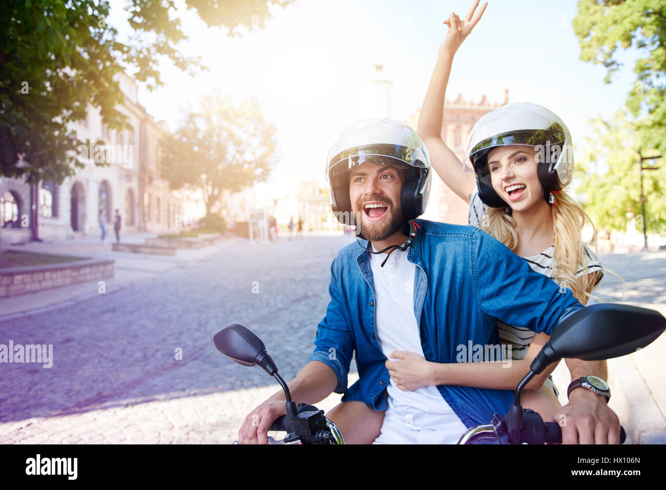 Couple riding a motorbike wearing helmets Stock Photo - Alamy