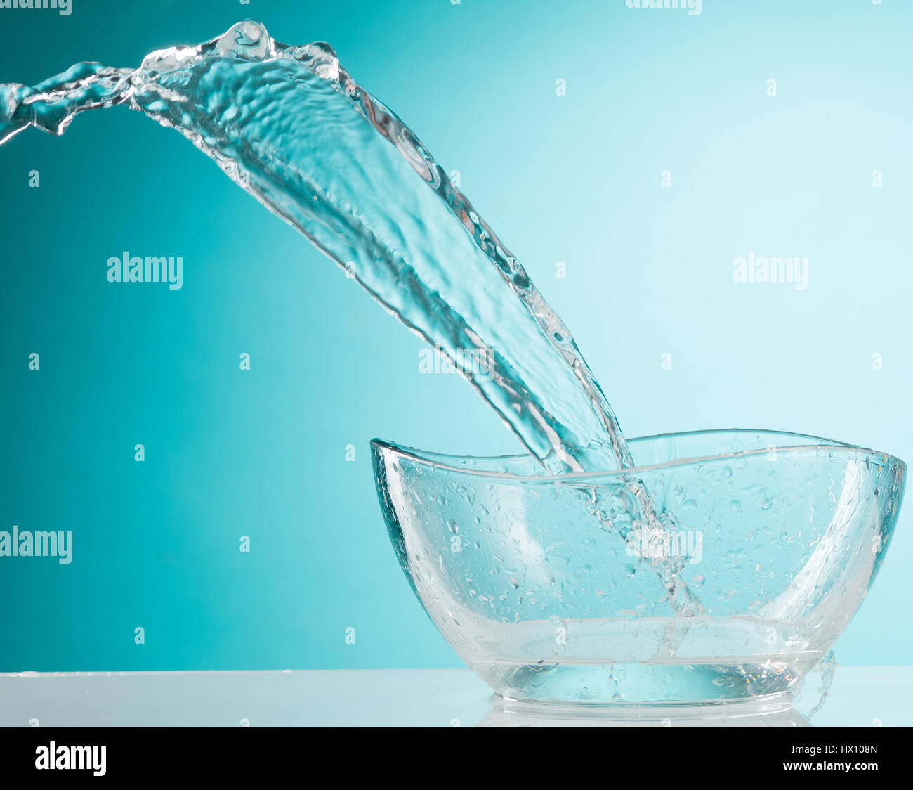 The water splashing to glass bowl on white background Stock Photo - Alamy