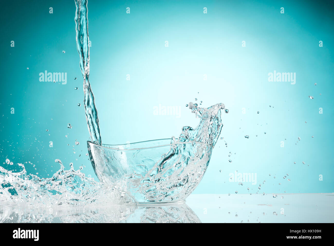 The water splashing to glass bowl on white background Stock Photo - Alamy