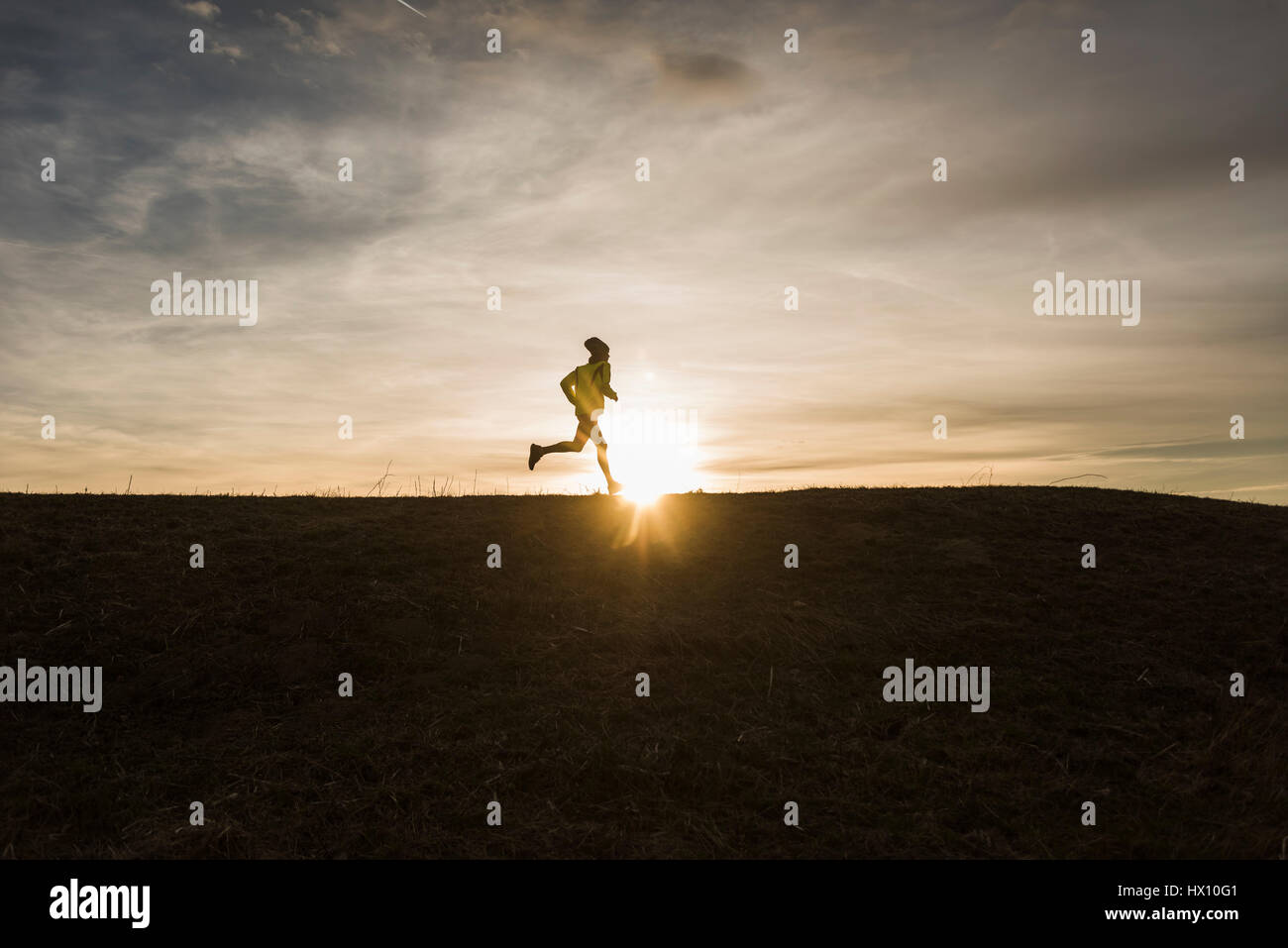 Man running in rural landscape at sunset Stock Photo - Alamy