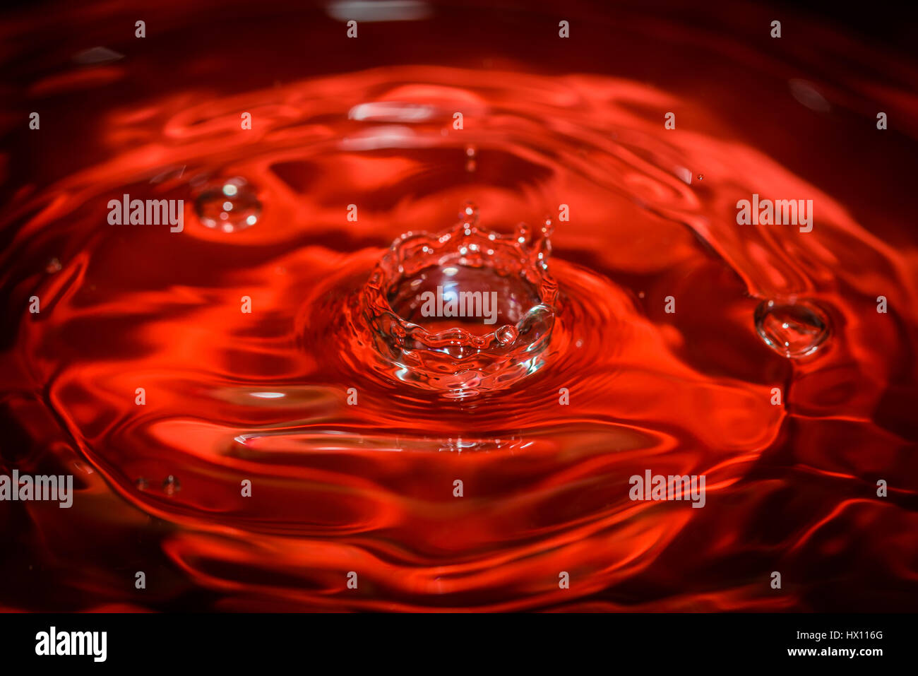 Water drop an waves with red background and reflection Stock Photo - Alamy