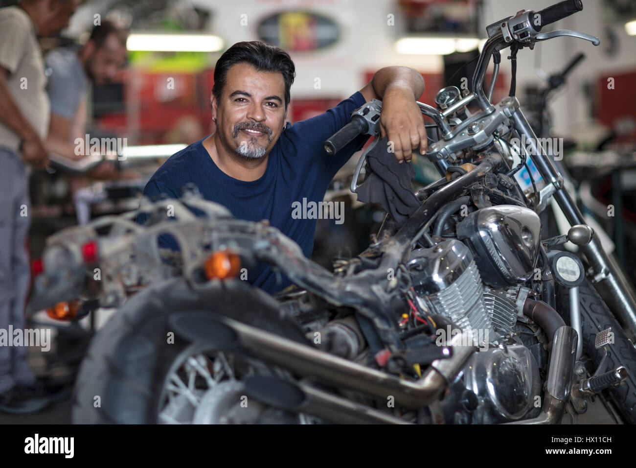 Portrait of smiling mechanic in motorcycle workshop Stock Photo - Alamy