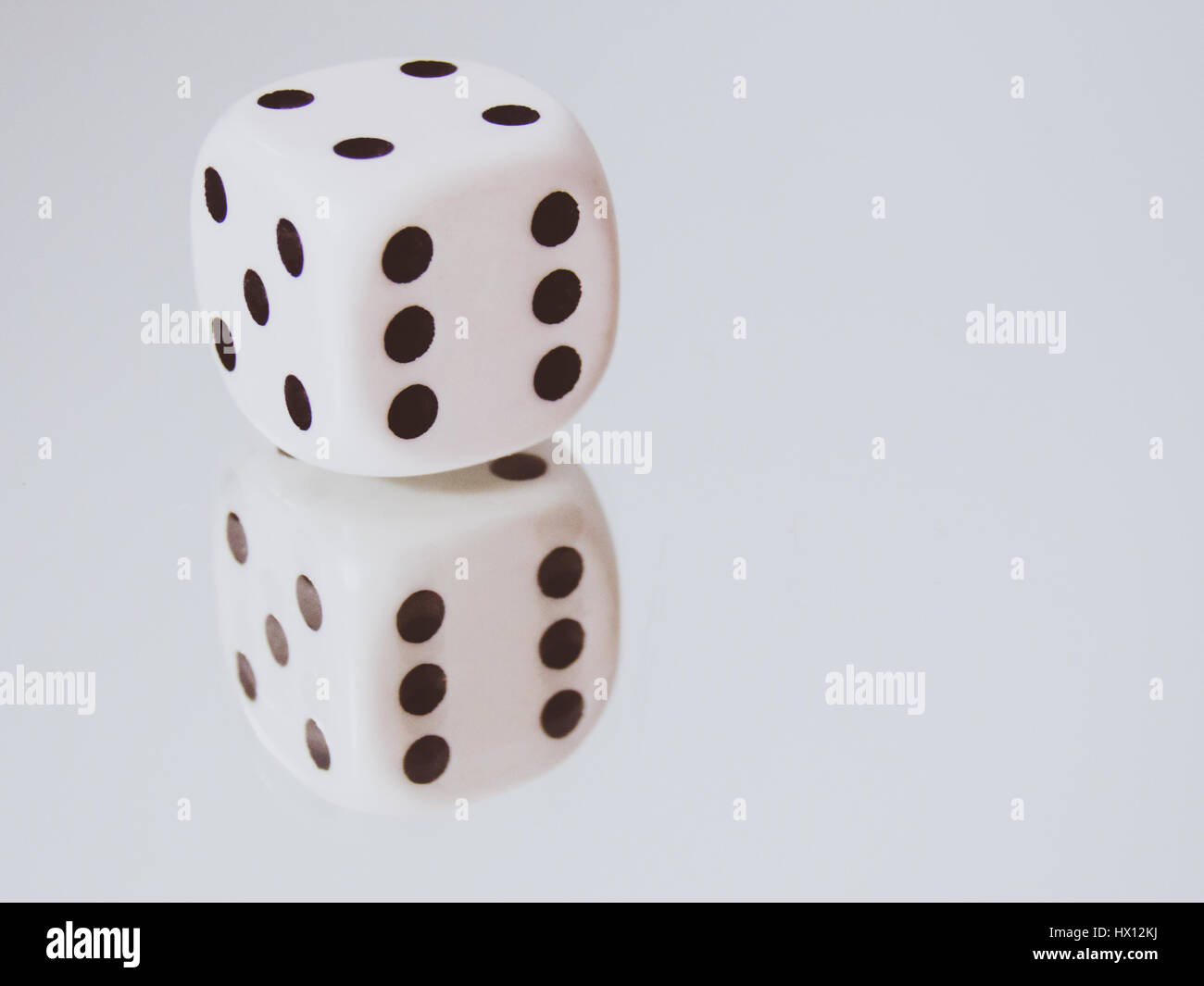 White cubic dice lying on a mirror Stock Photo - Alamy