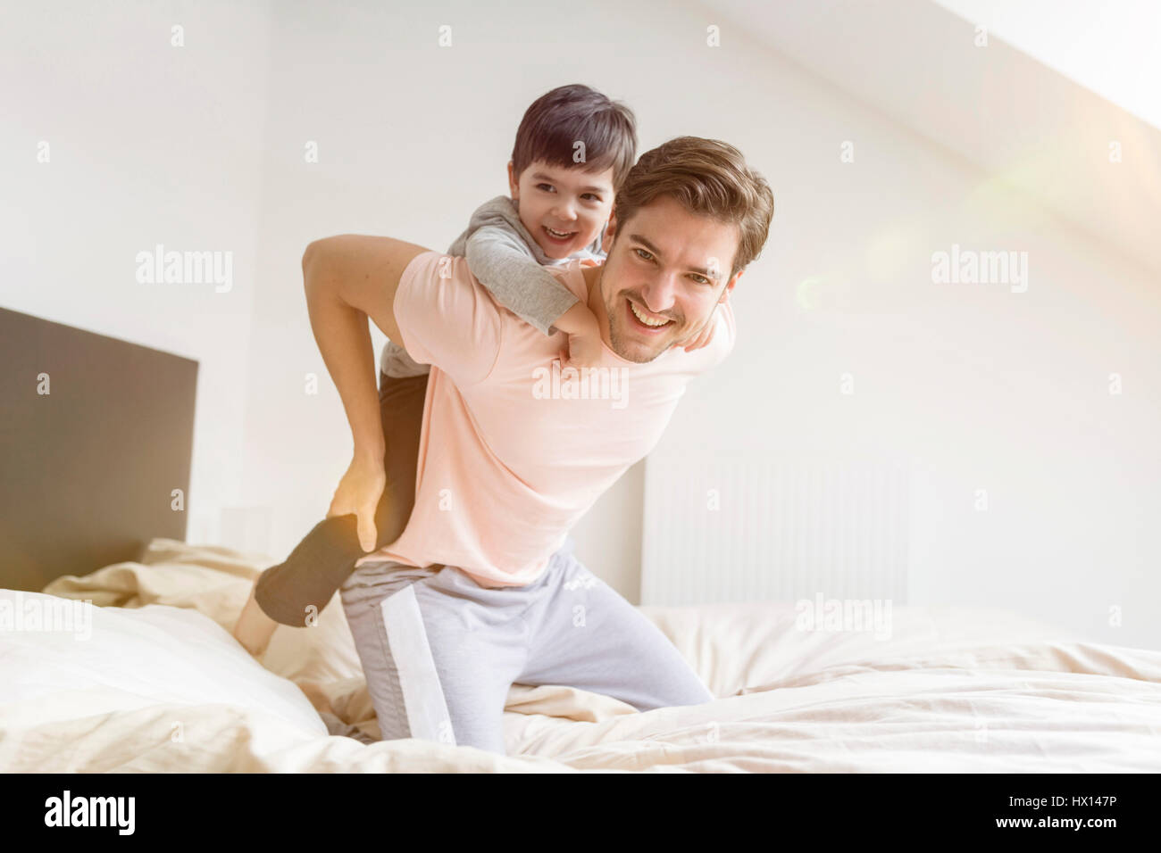 Happy father and son playing in bed Stock Photo - Alamy