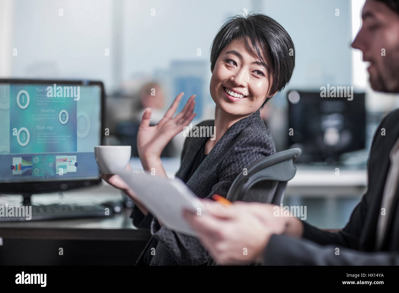 Smiling woman talking to colleauge in city office Stock Photo - Alamy