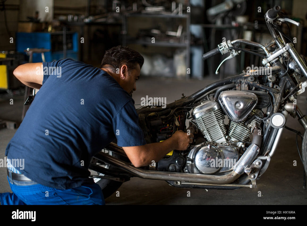 Mechanic examining motorbike hi-res stock photography and images - Alamy