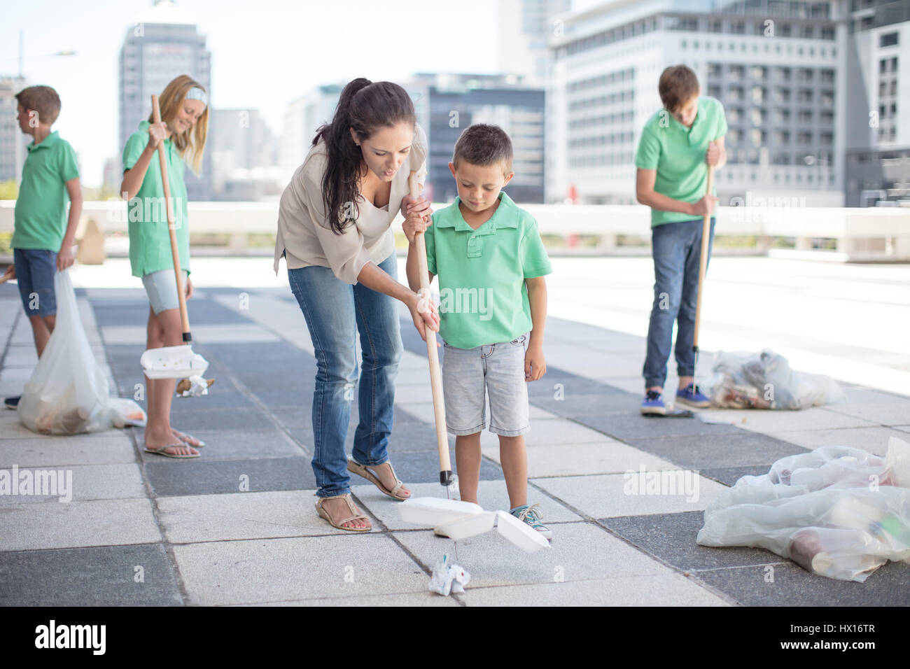 Group of volunteering children collecting garbage with litter sticks ...