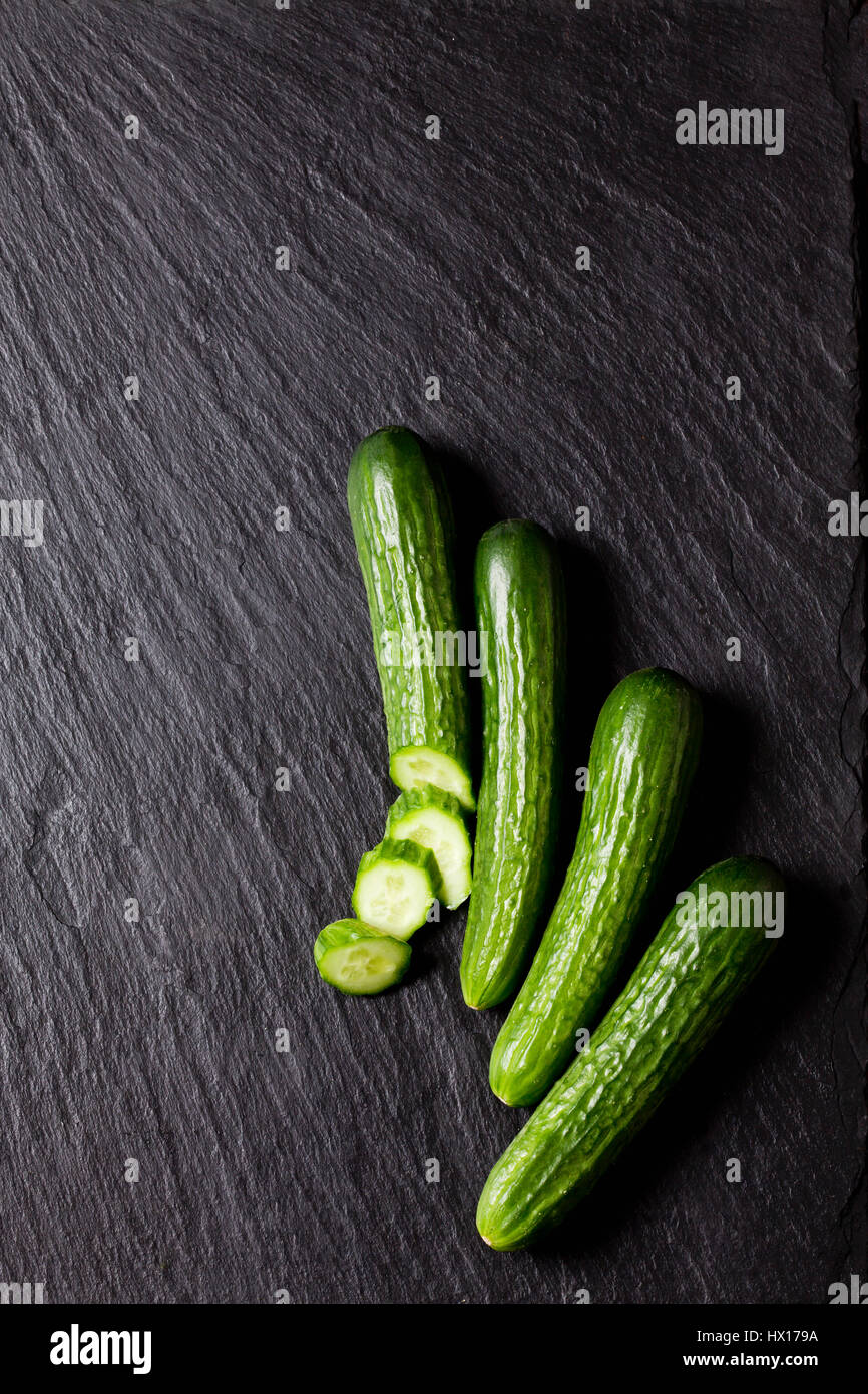 Sliced and whole mini cucumber on slate Stock Photo - Alamy
