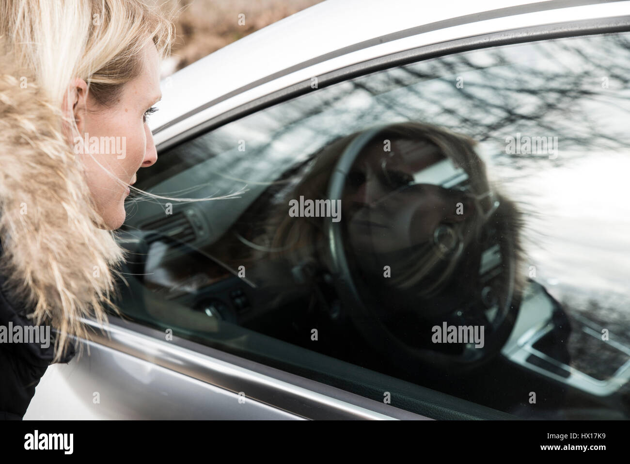 Woman looking in car Stock Photo - Alamy