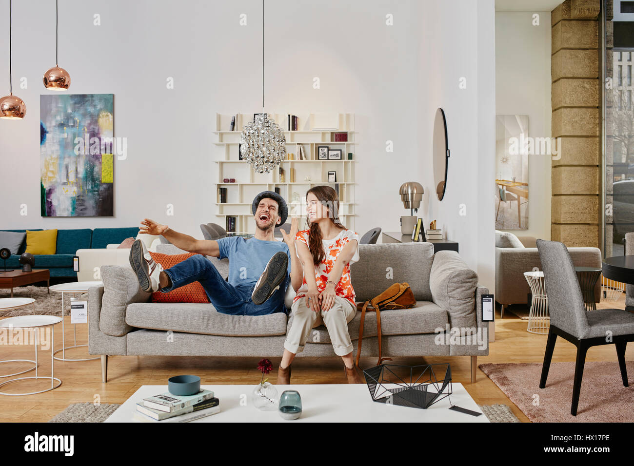 Couple in modern furniture store testing couch, being happy Stock Photo ...