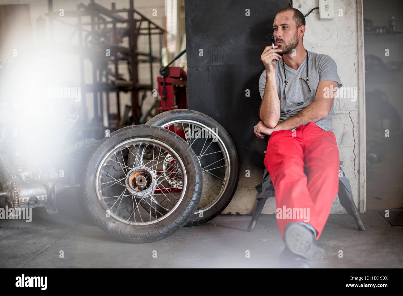 Mechanic in workshop smoking a cigarette Stock Photo - Alamy