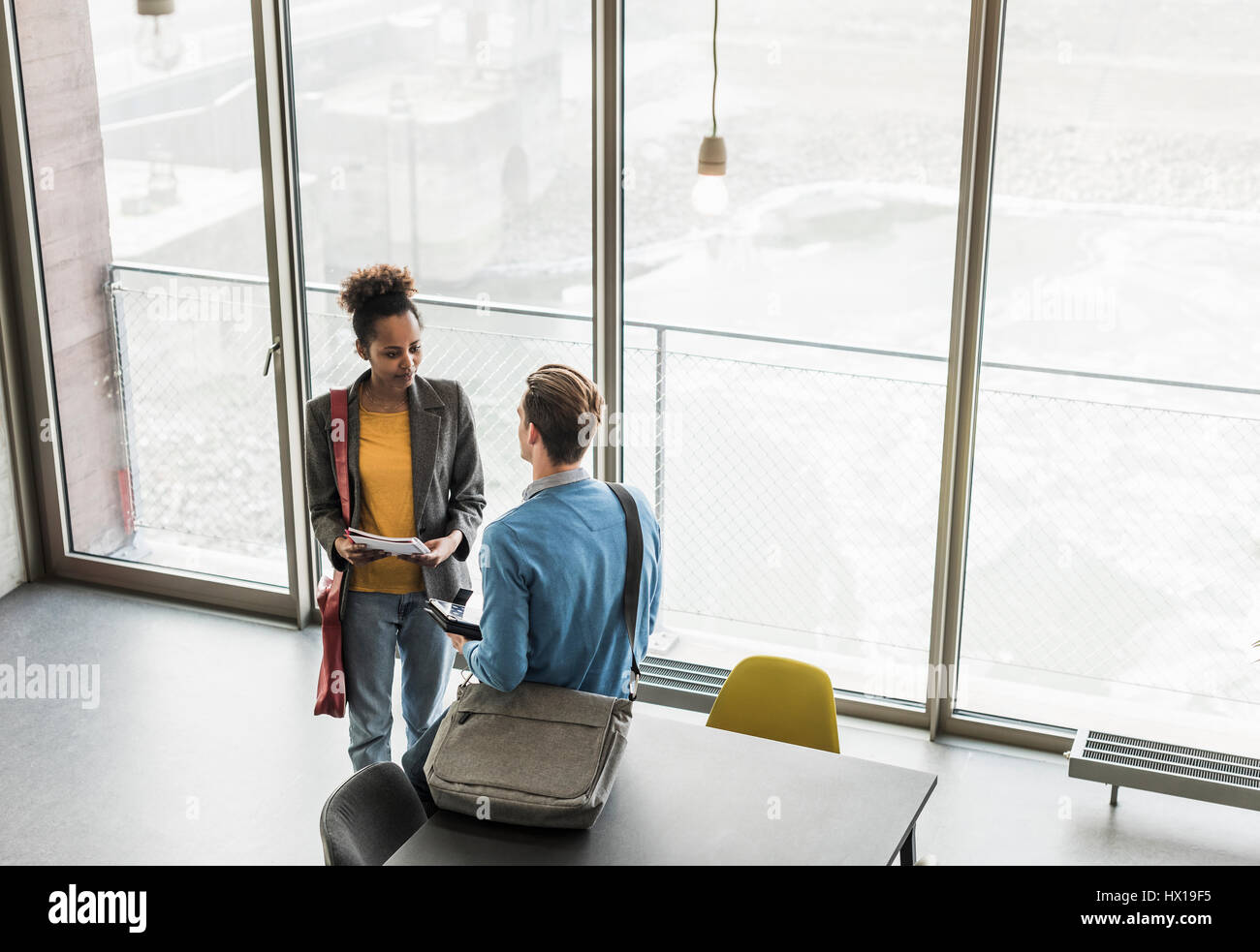 Young business people discussing files in office Stock Photo - Alamy