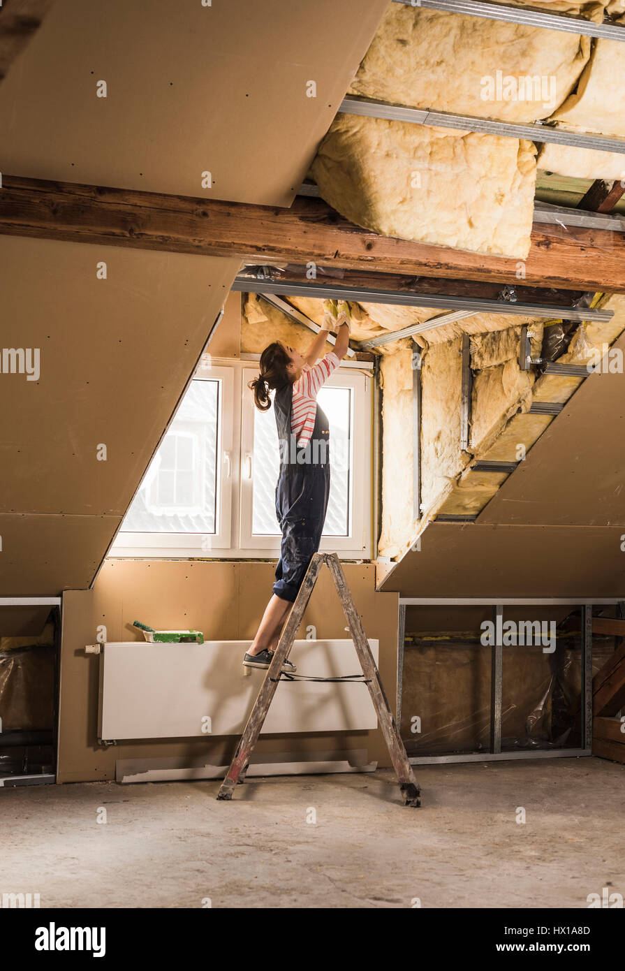 Young woman mounting insulation in her new home Stock Photo - Alamy