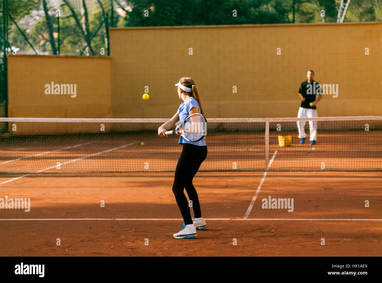 Teenage girl training tennis with her teacher Stock Photo - Alamy