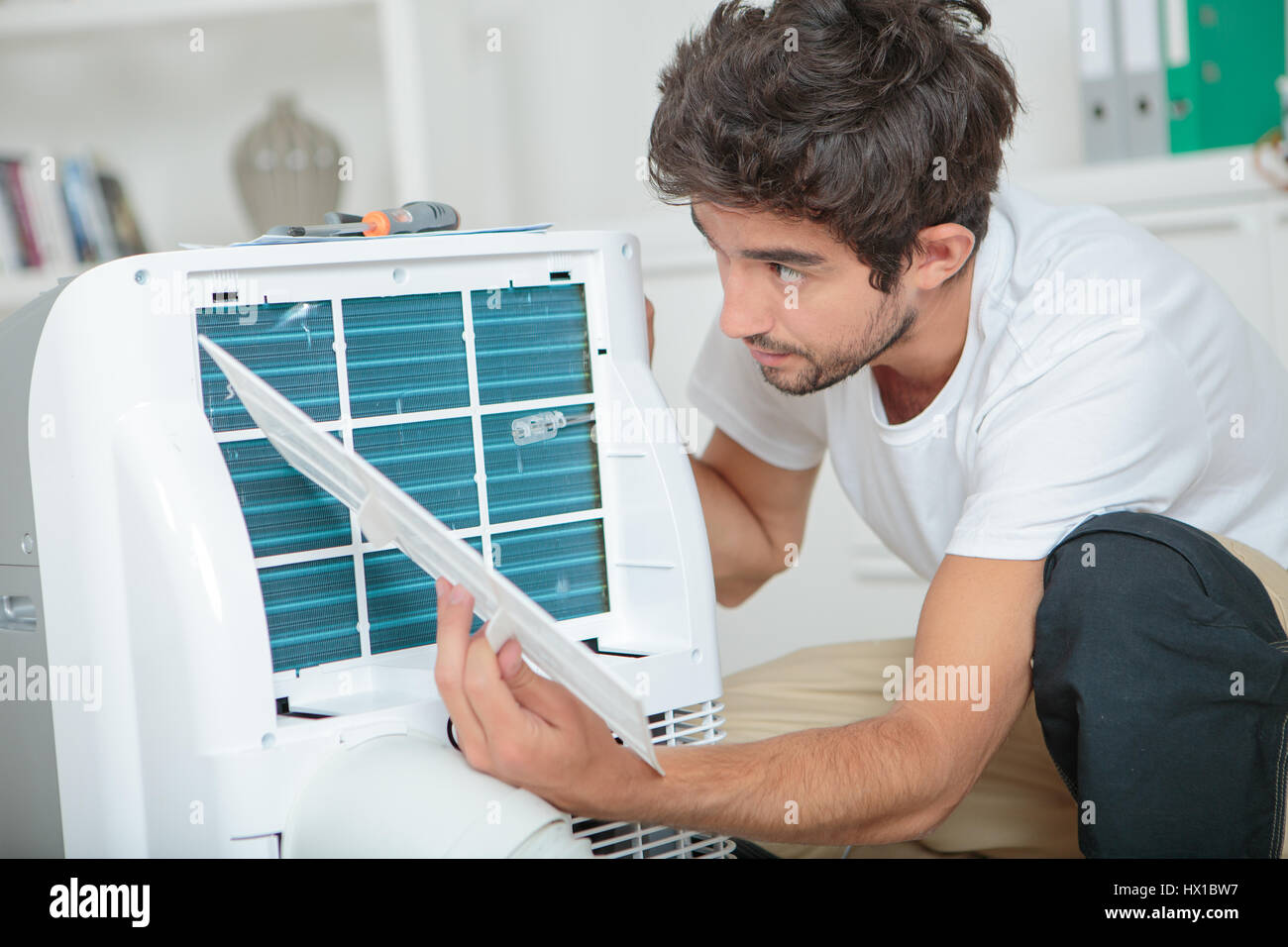 Man working on air conditioning unit Stock Photo - Alamy