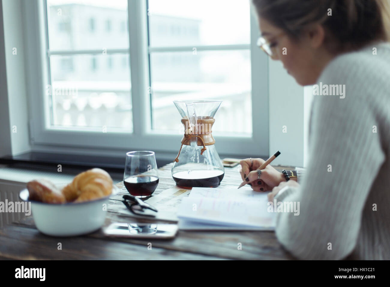 Young woman working at table at home Stock Photo - Alamy