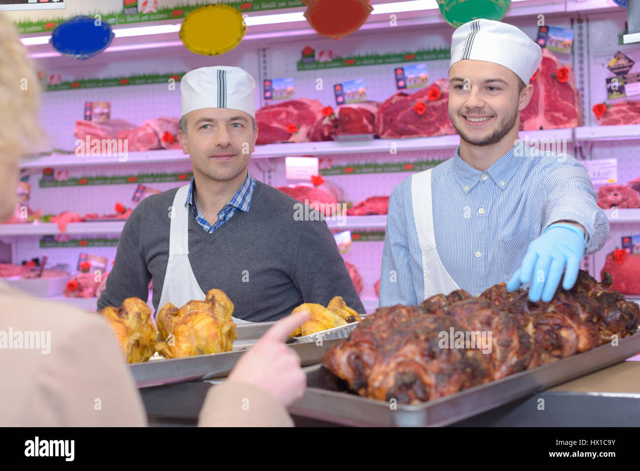butcher teaching a young one how to sell meat Stock Photo - Alamy
