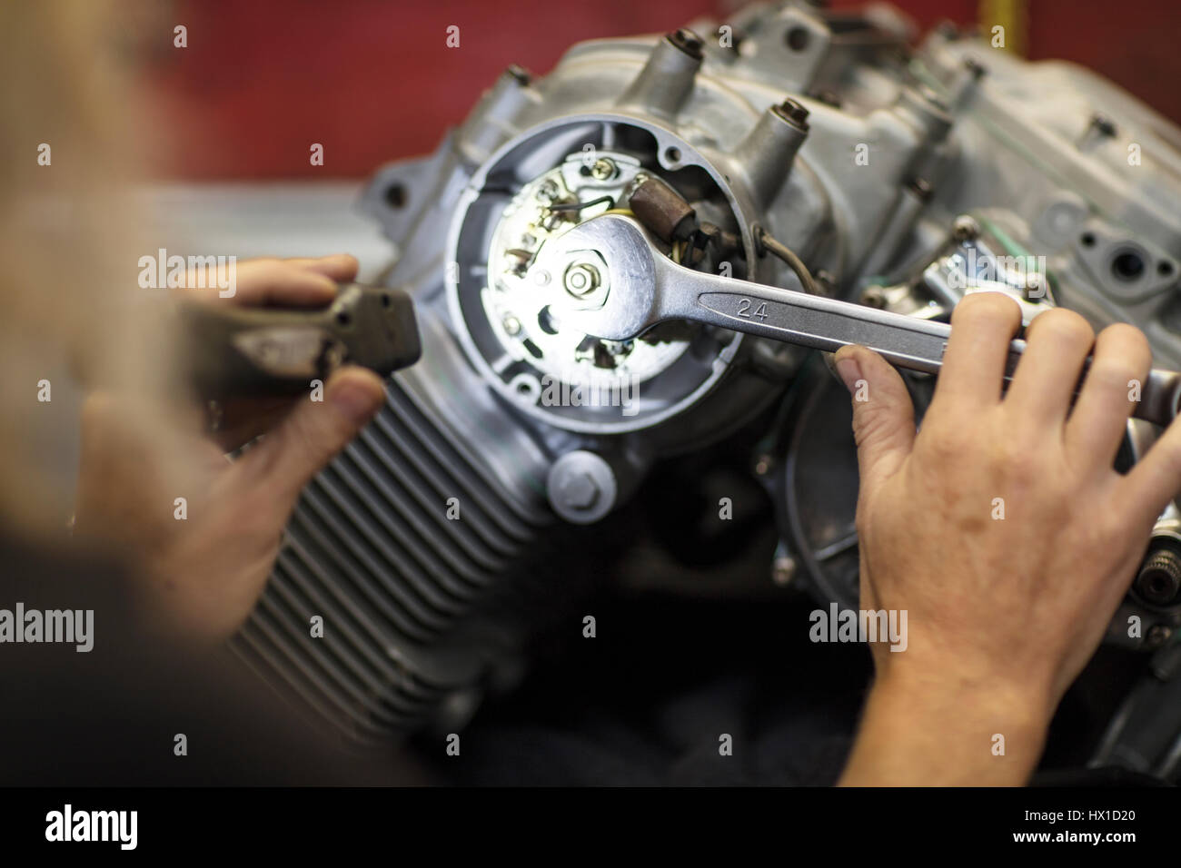 Mechanic working on motorcycle engine in workshop Stock Photo - Alamy