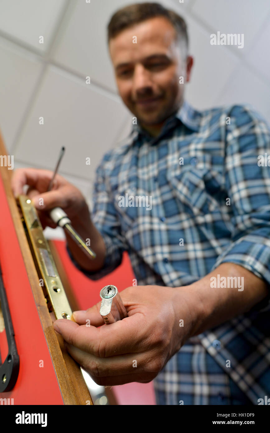 Man fitting a new door lock Stock Photo - Alamy