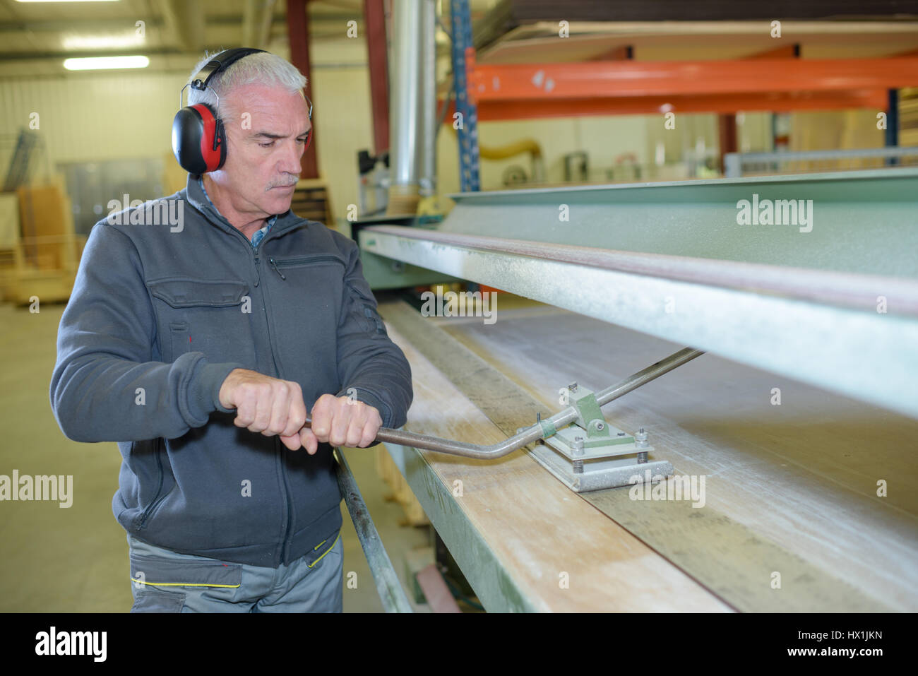 Worker jacking factory machine Stock Photo - Alamy