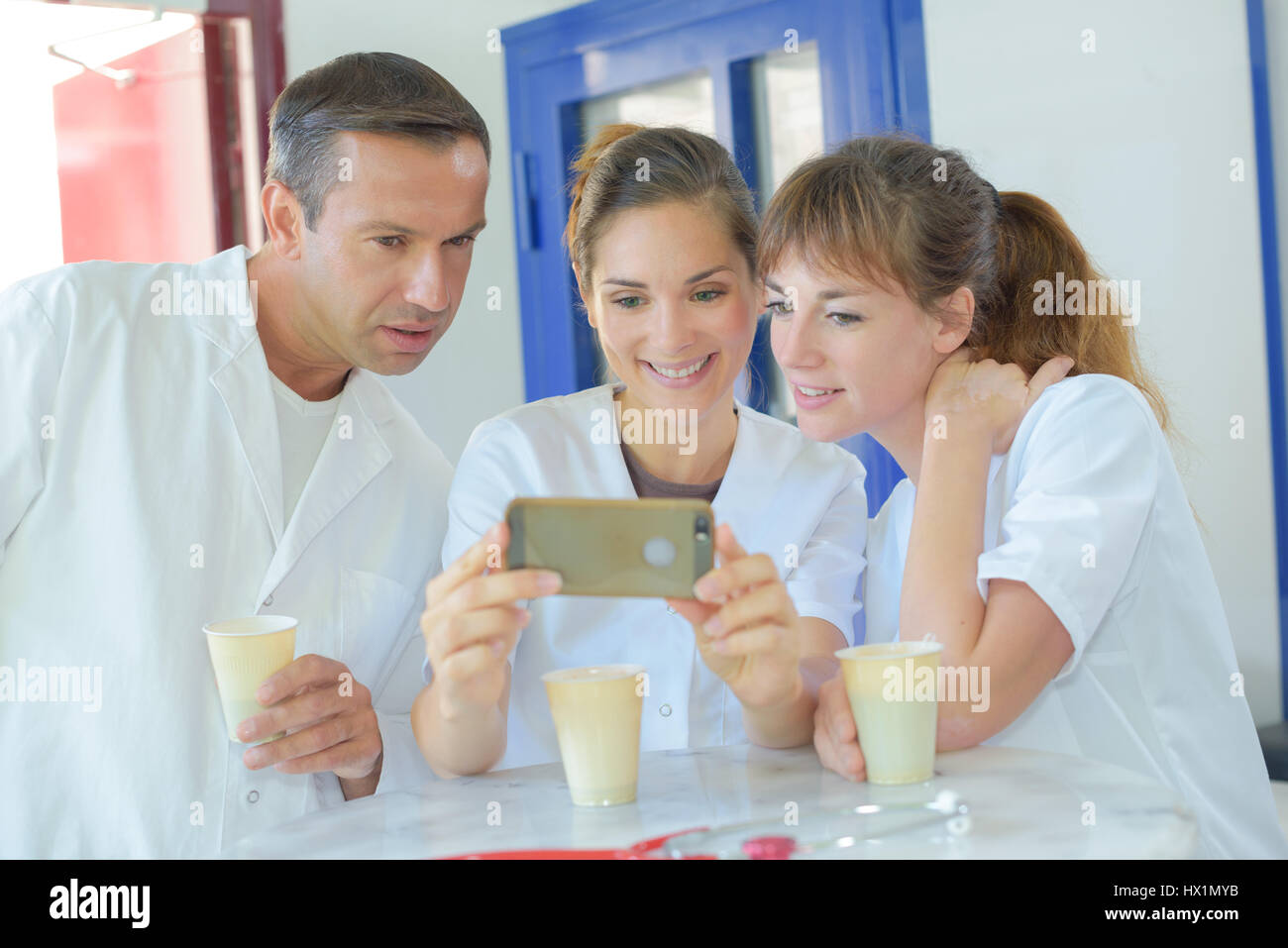 Medical staff on break, looking at cell phone Stock Photo - Alamy