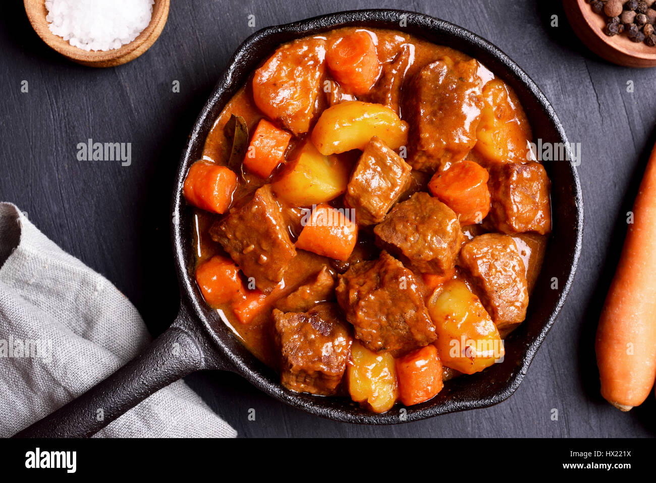 Beef stew in frying pan on dark background, top view Stock Photo - Alamy